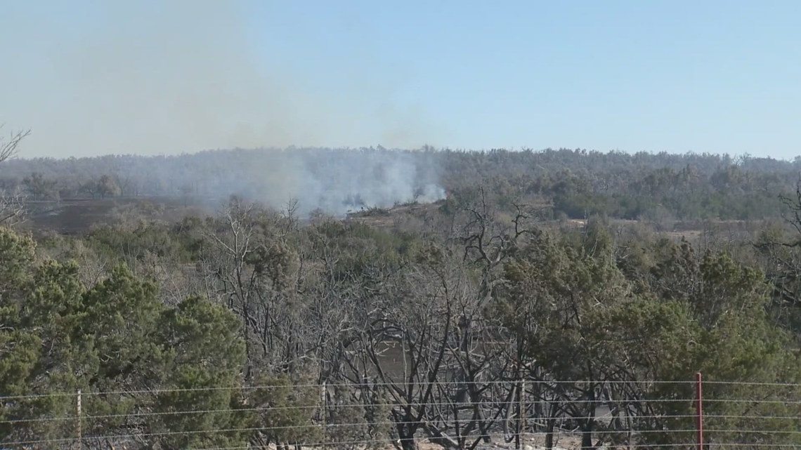 Fire crews work against strong winds to put out hot spots of wildfire ...